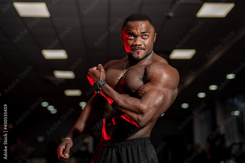 Foto de Athlete with very big muscles shows strong hands in gym ...