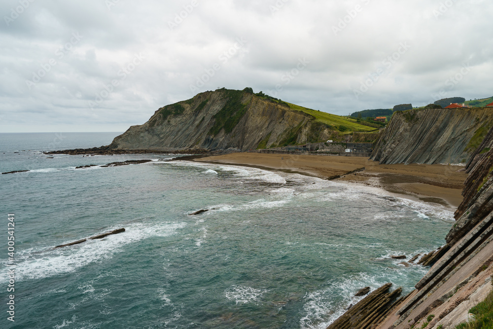 Charming Zumaia Itzurun beach. Steeply-tilted layers of flysch ...