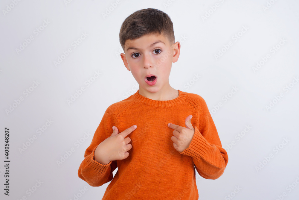 Embarrassed Cute Caucasian kid boy wearing knitted sweater indicates at ...