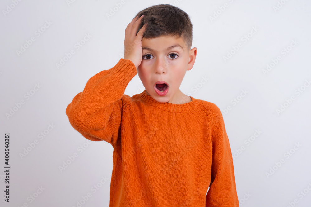 Embarrassed Cute Caucasian kid boy wearing knitted sweater against ...