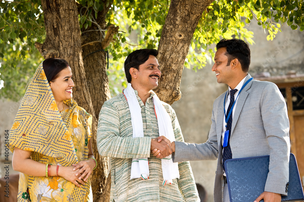 Rural Indian couple with farmer and bank executive shaking hands in ...