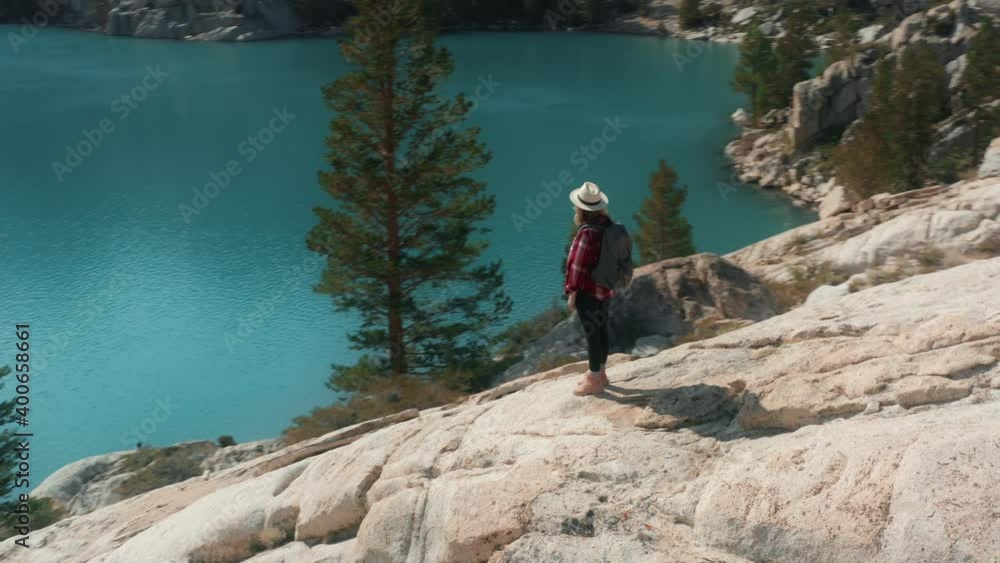 Woman enjoying mountain lake, 4K aerial. Drone flying around woman ...