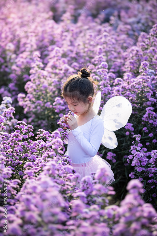 Cute little girl smelling flowers and wear a magic ballet fairy costume ...