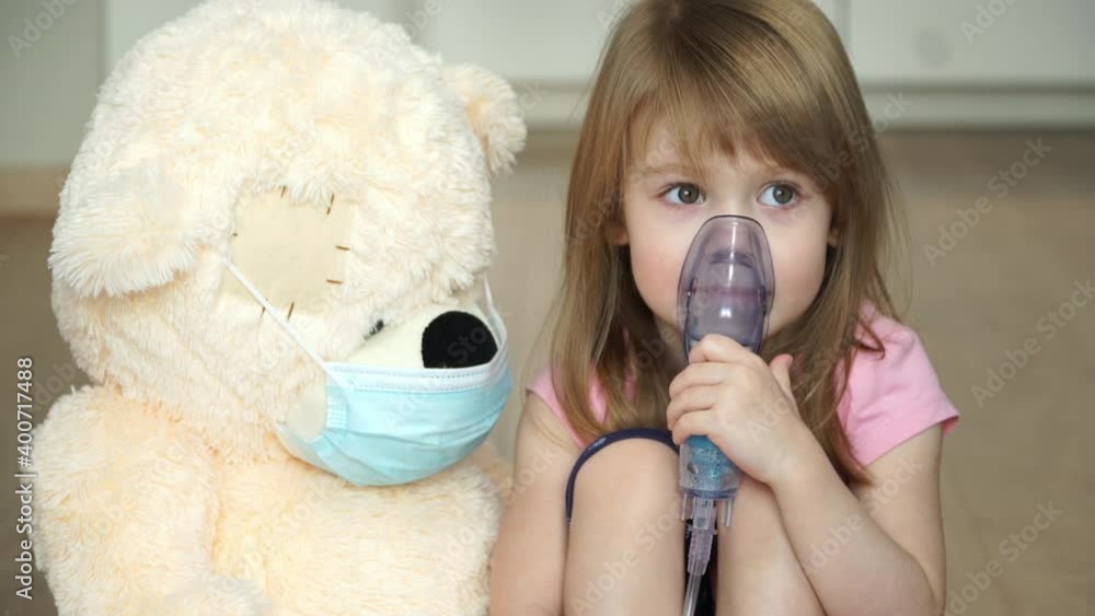 Portrait of little girl does procedure with medication nebulizer and ...