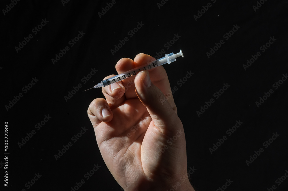 Hand with injection syringe on black background ภาพถ่ายสต็อก | Adobe Stock
