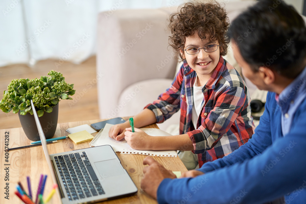 Cute learner. Portrait of joyful little hispanic school boy doing ...
