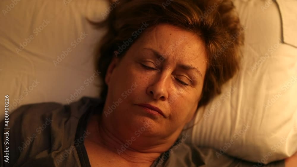Older woman lying in bed unable to sleep Stock Video | Adobe Stock