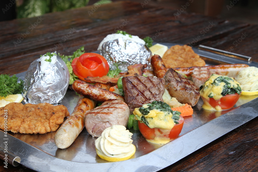 Huge mixed grill platter with crumbed pork escalope, beef steaks, pork ...