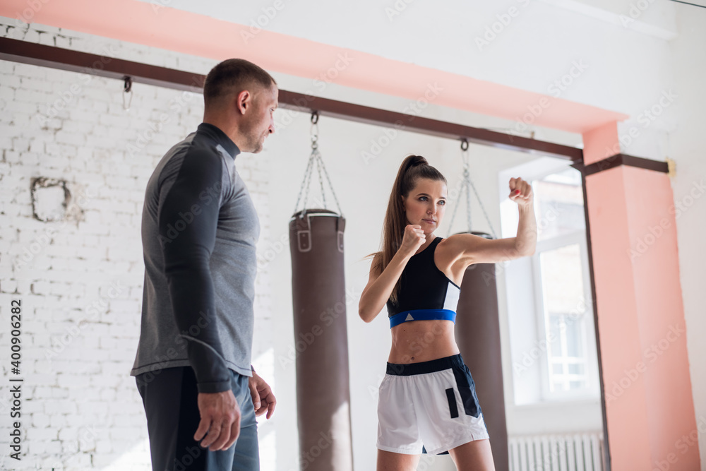 An attractive young boxer teaches his girlfriend boxing techniques in a ...