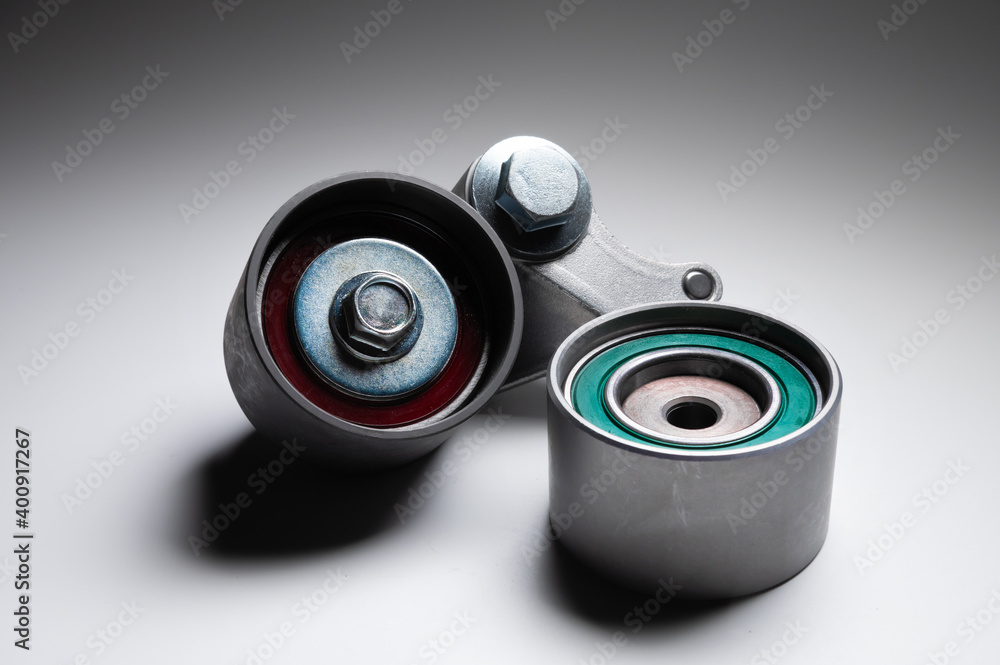 Two tensioning rollers of the engine timing belt on a gray background ...