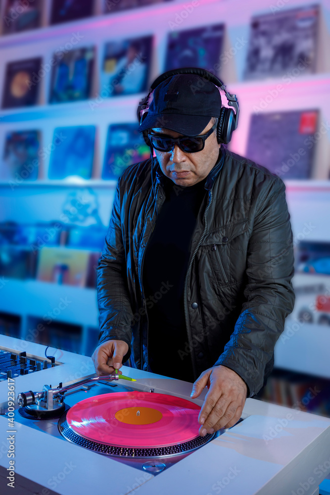 Dj mezclando música en un tornamesa con discos de vinil, y escuchando ...