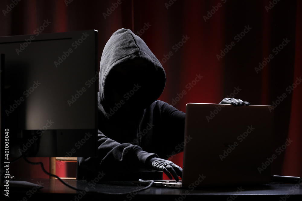International hacker in black pullover and black mask trying to hack ...