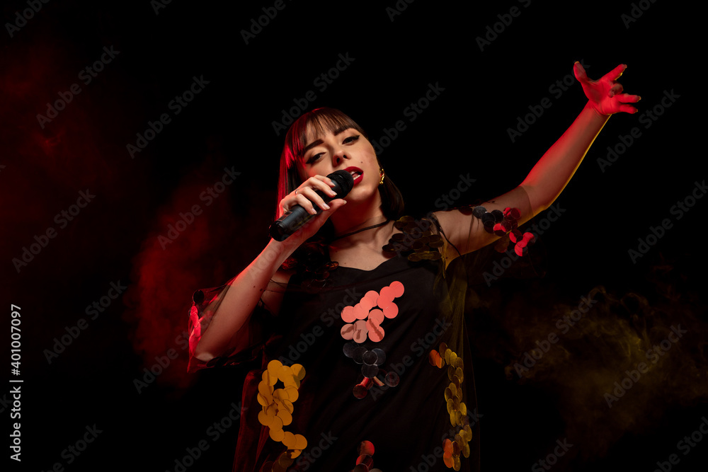 Caucasian female singer portrait isolated on dark studio background in ...