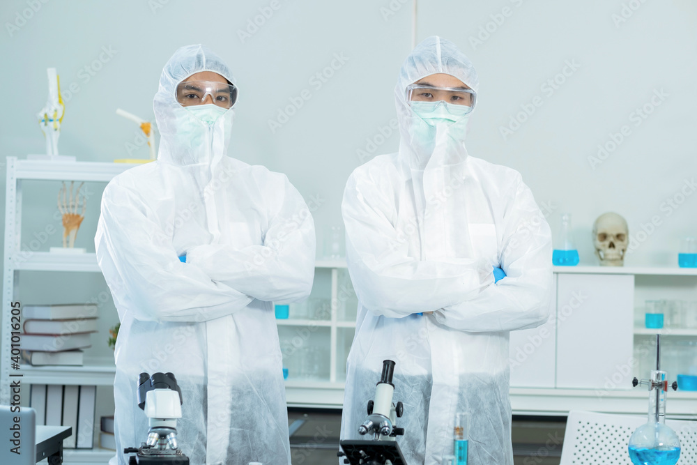 Two scientists wearing personal protective and safety glass standing ...