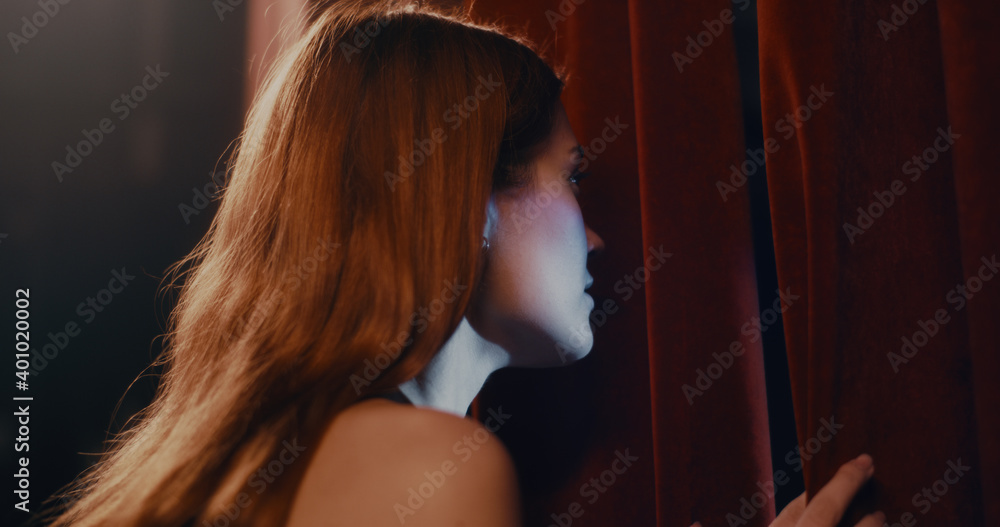 Anxious actress looking at stage from behind curtains Stock Photo ...