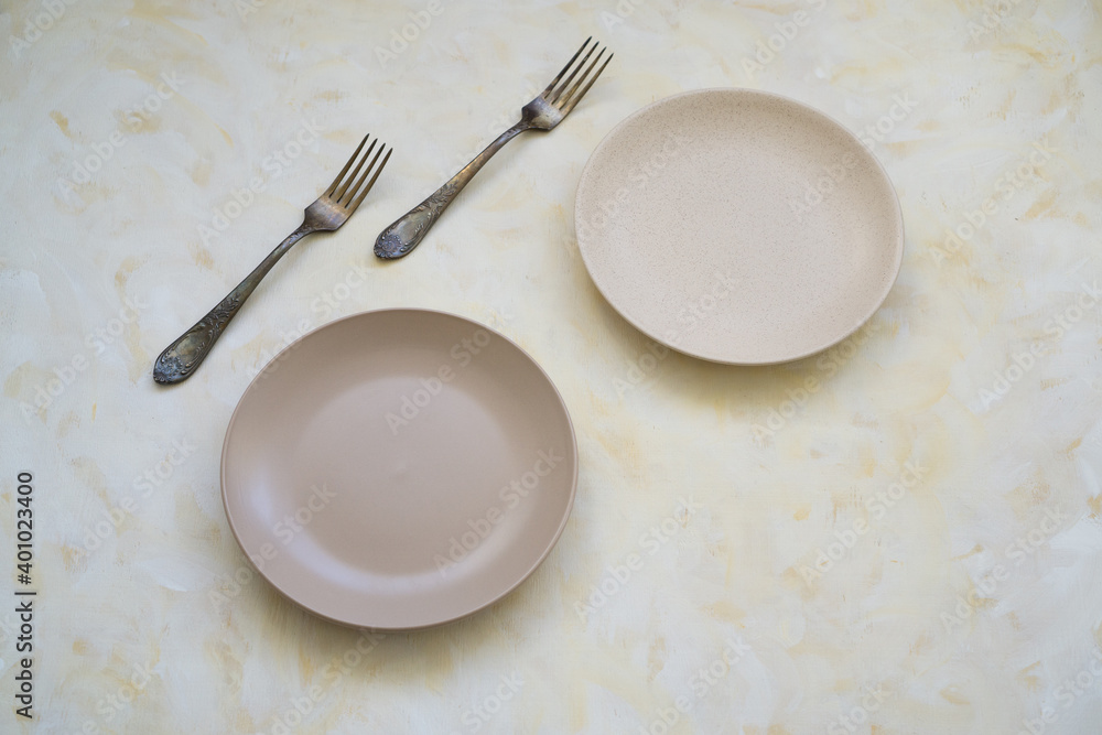 Plates and cutlery on a light surface. Table setting for two people ...
