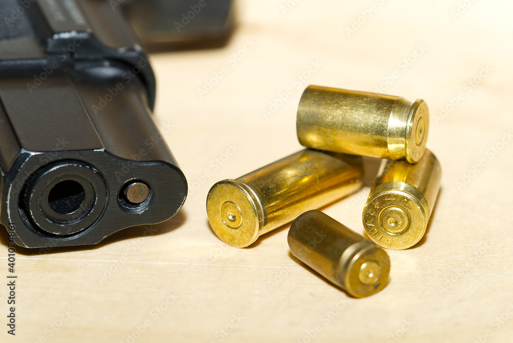 shell casings and barrel of a pistol close-up on a wooden table in a ...