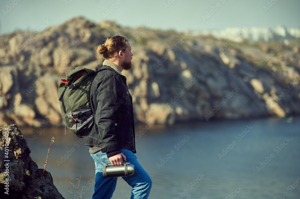 Side view of a hiker with backpack admiring landscape on high peaks and ...
