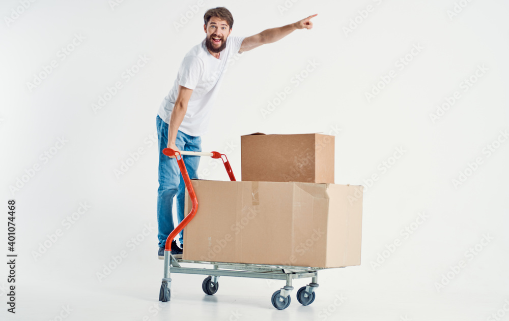 cardboard boxes on a cargo trolley and happy men gesturing with hands ...