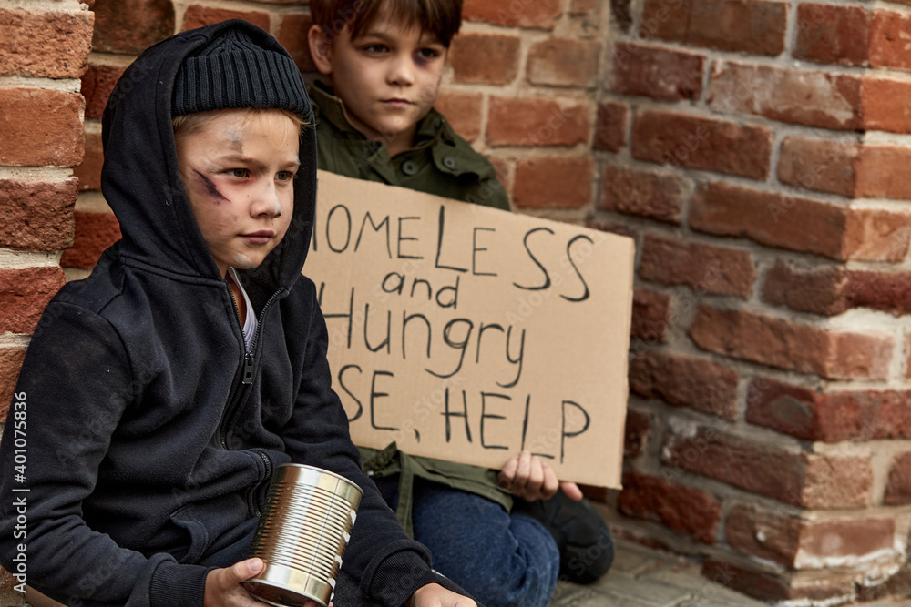 poor little children begging in the buzy street in big city, boys look ...