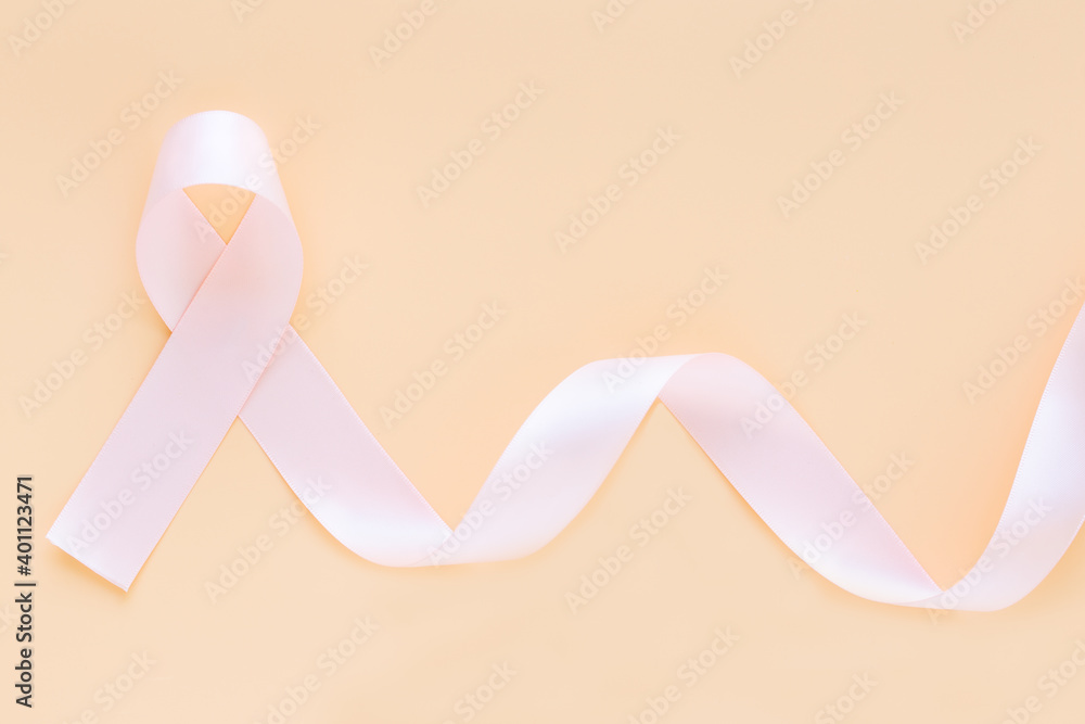Peach color ribbon curl on pastel orange or beige color background with ...