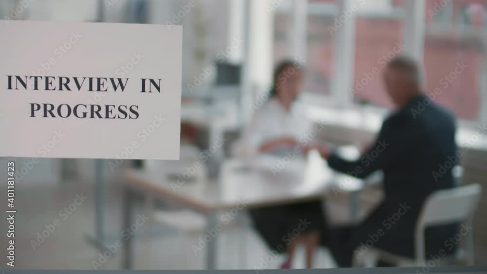 Interview in progress sign printed on paper hanging on glass door in ...
