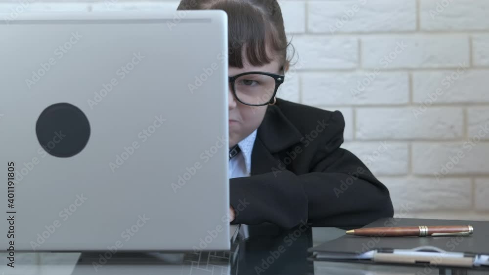 Child have fun in the office. A little boss has fun on the work place ...