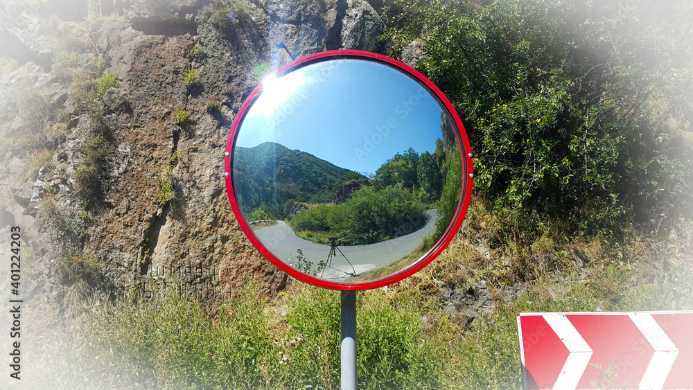 Road mirror. Round mirror placed on the turn on the road for safe ...