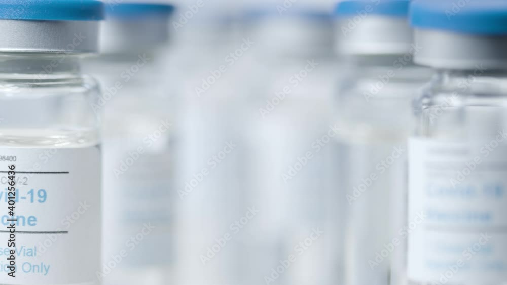 Extreme Close Up Pull Focus Shot Through Multiple Vials of Covid ...