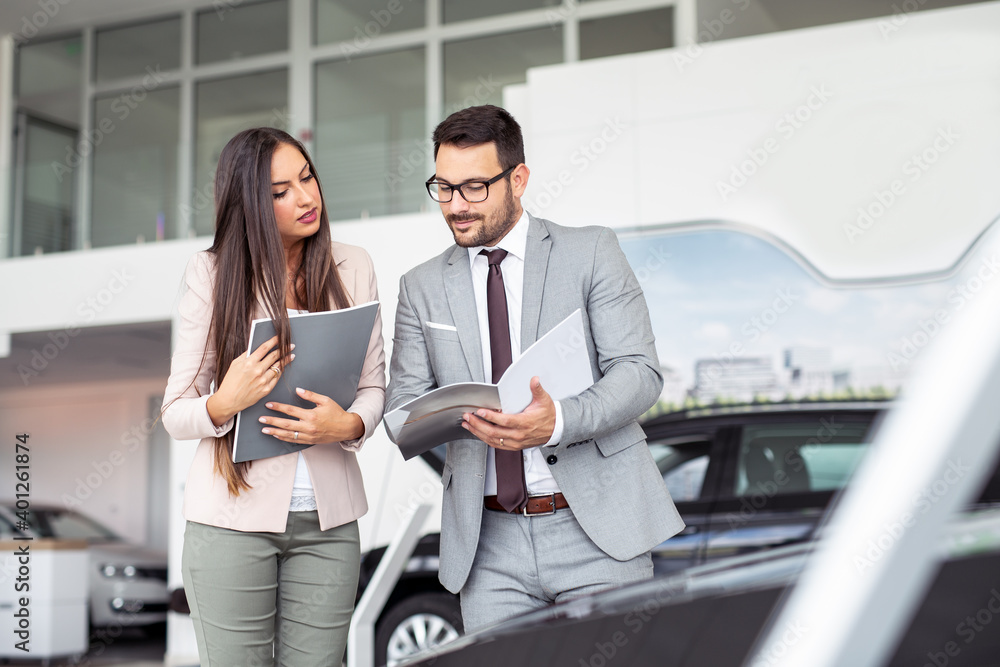 Salesperson selling cars at car dealership. Stock Photo | Adobe Stock