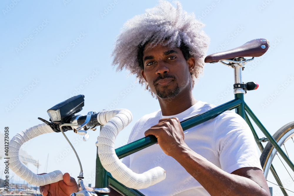 Afro and black man carrying a city bike on his back. Black rider and ...