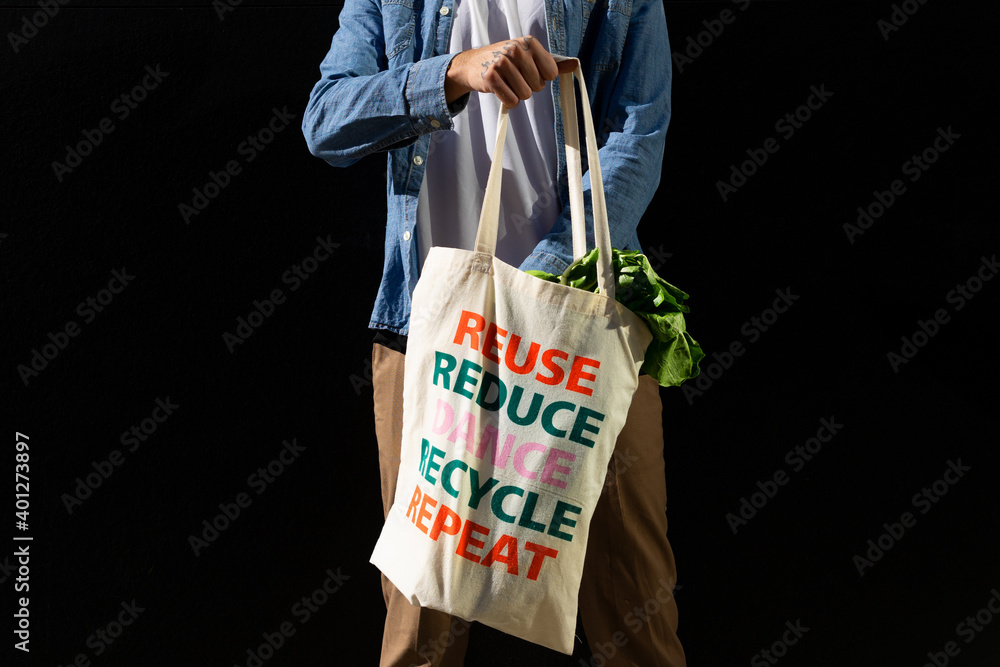 Crop anonymous male buyer holding fabric shopping bag with text message ...
