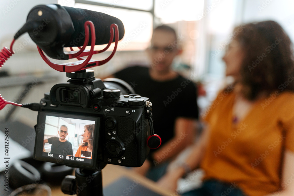 Professional camera with microphone on tripod recording video with ...