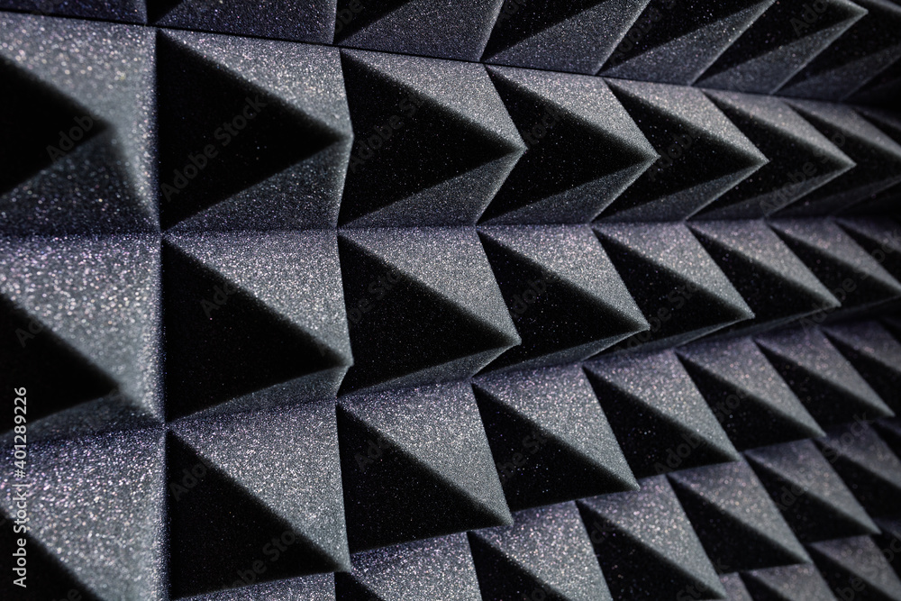 Textured background of wall with black geometric soundproof foam with ...