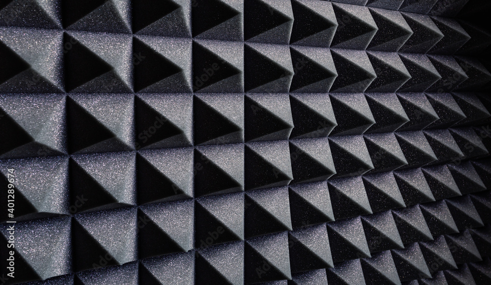 Textured background of wall with black geometric soundproof foam with ...