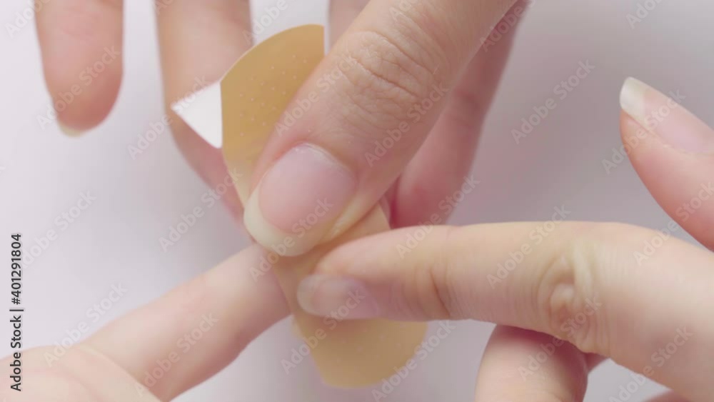 Apply a patch on the child's finger. Mother hands applying ...