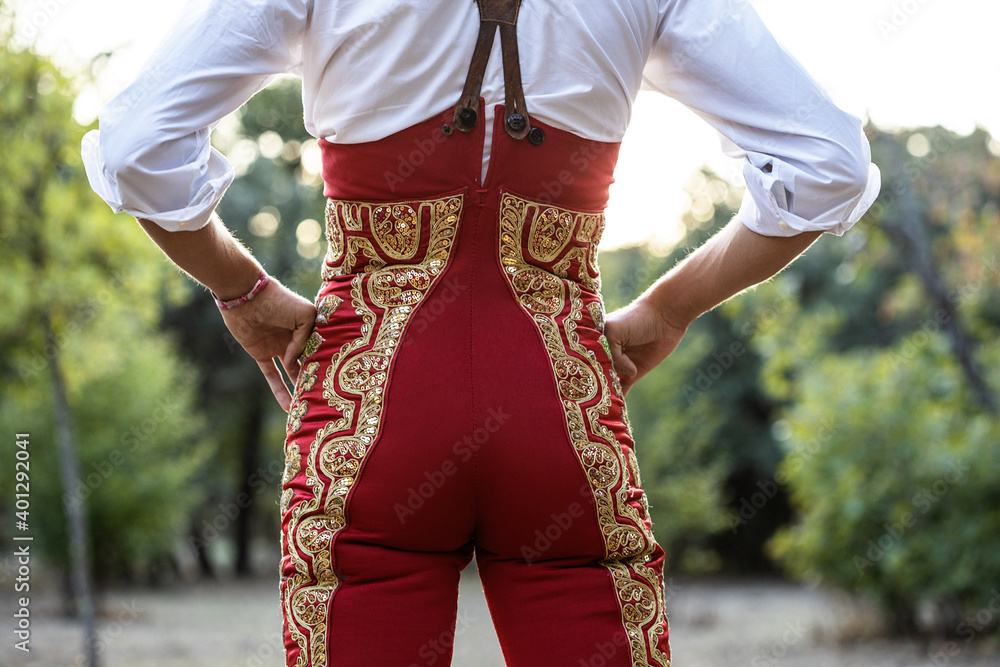 Back view of unrecognizable young matador wearing red traditional ...