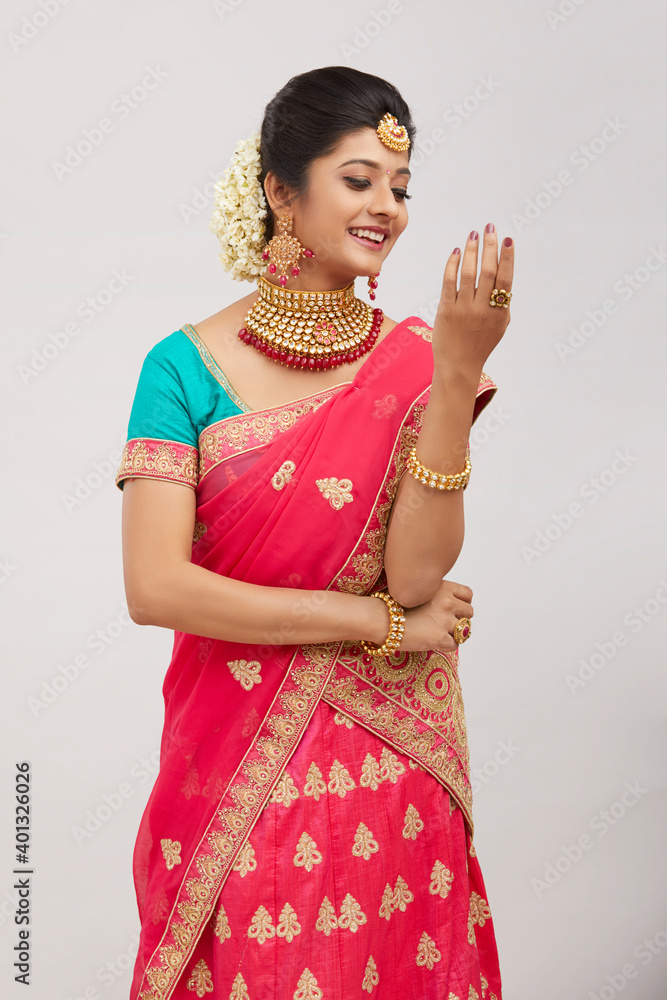 Beautiful Indian girl in traditional outfit with jewelry in studio shot ...