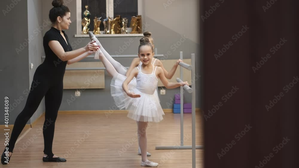 Ballet teacher teaching young dancers. Female ballet teacher helping ...