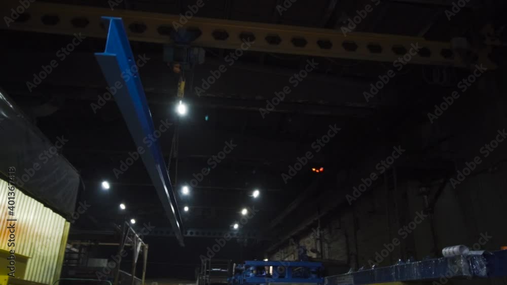 Metal beam is moved on chains in factory. Clip. Steel beam suspended on ...