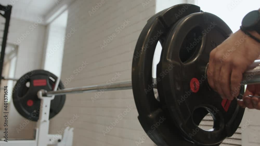 Young bodybuilder doing bench press with a barbell in training in the ...