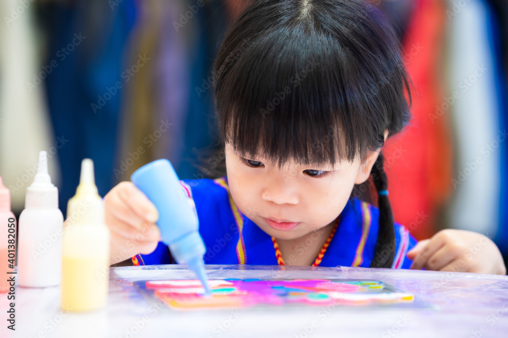 Children make crafts. Girl make art by dripping paint from plastic ...