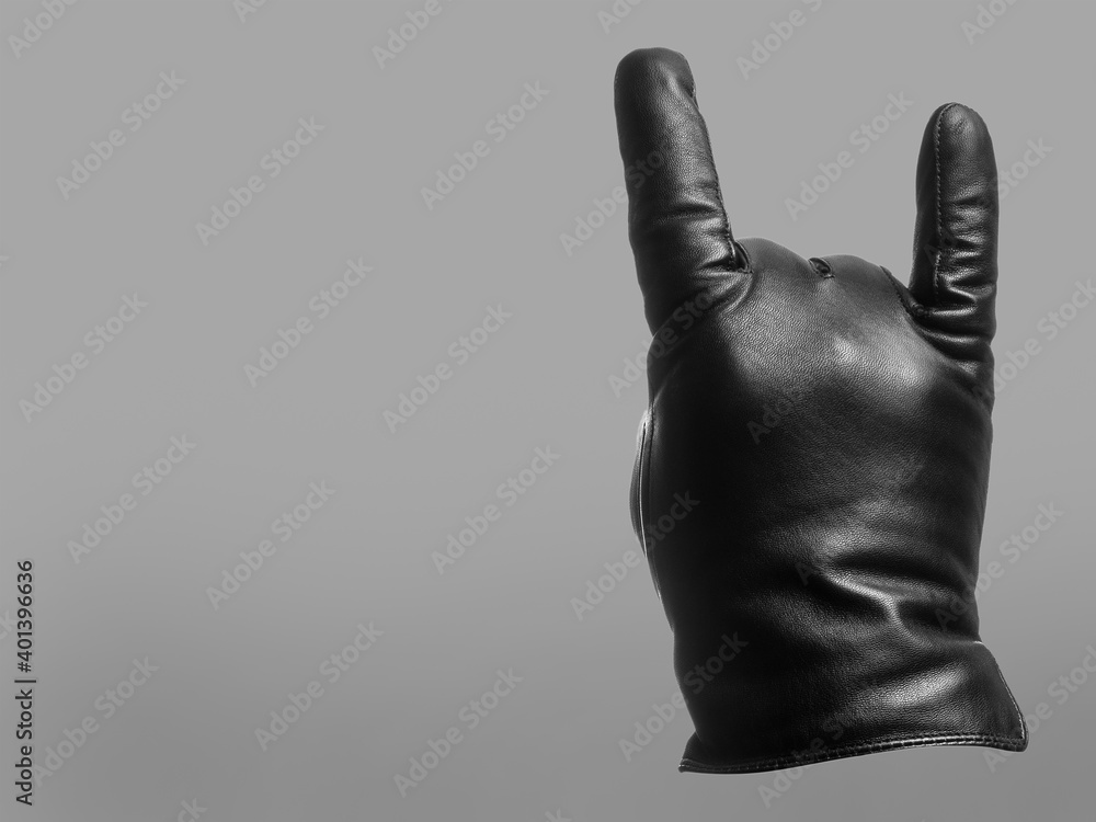 black leather glove shows rock sign out gesture. isolated neutral ...