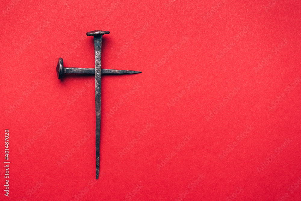 Cross made with rusty nails and drops of blood on red background. Copy ...