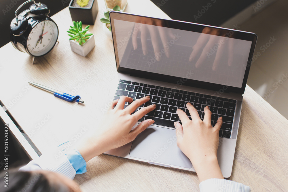 Hand of woman typing on blank screen laptop keyboard in office table ...