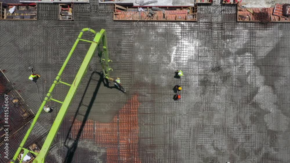 Concrete Pump operation in a large Construction site, with workers ...