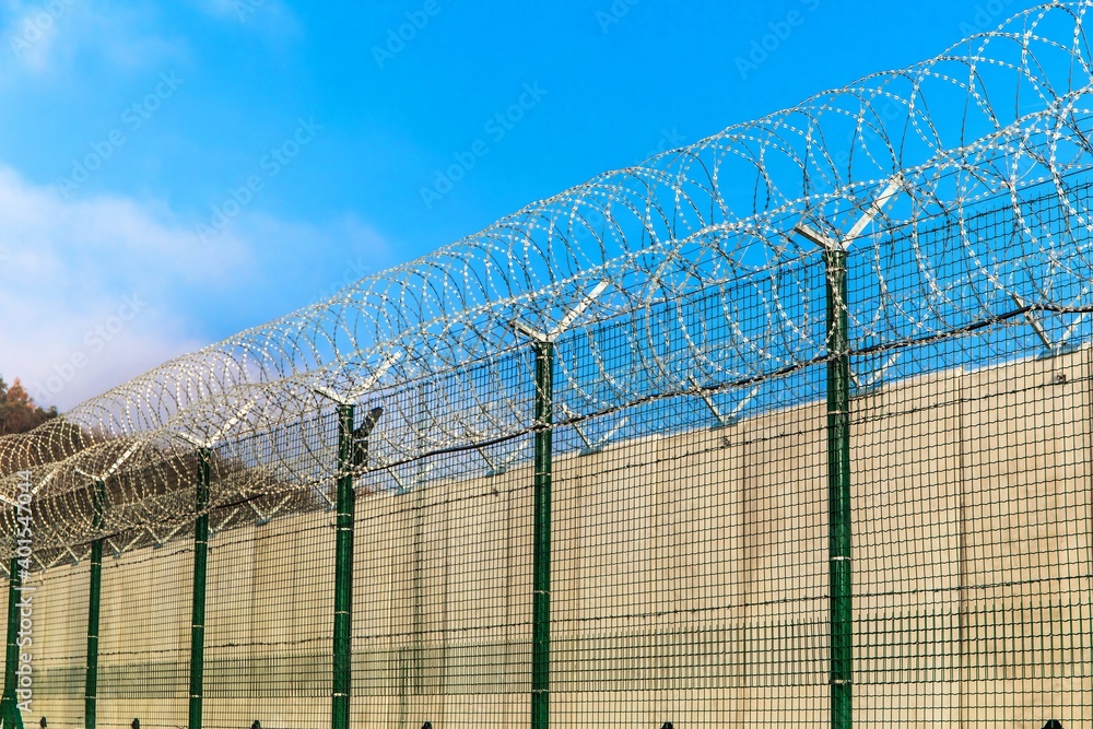 Barbed wire against a blue sky. Prison concept. Entry order. Military ...