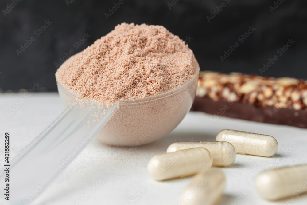 Scoop of whey or soy protein isolate, chocolate protein bar, white ...