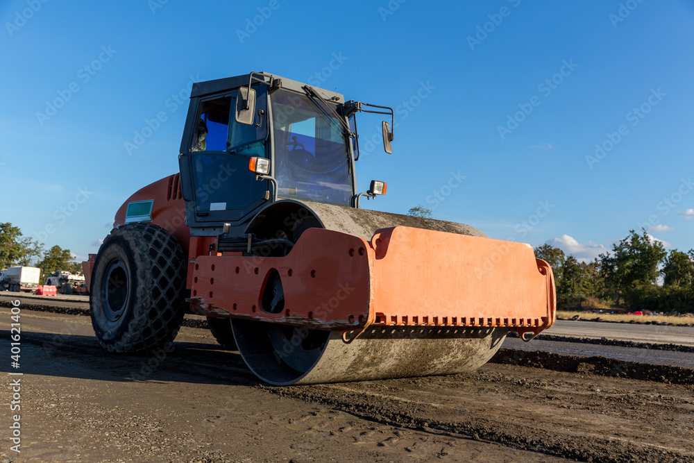 Foto de Vibratory soil compactor working on highway construction site ...