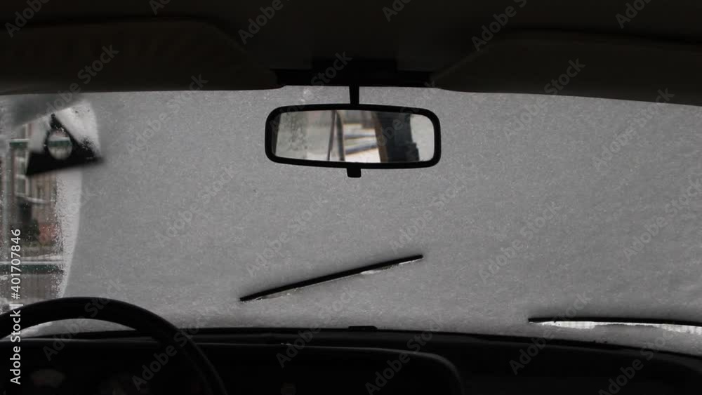 Scratching ice and cleaning snow with a brush from a vintage car ...